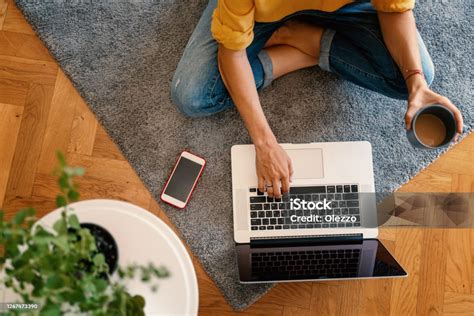 노란 셔츠를 입은 여성은 카펫 원격 작업 및 교육 최고 전망의 거실에서 집에서 커피 한 잔을 들고 노트북에서 일합니다 카페트에 대한 스톡 사진 및 기타 이미지 Istock