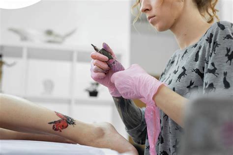 特写镜头女艺术家使颜色纹身腿年轻的女孩纹 包图企业站