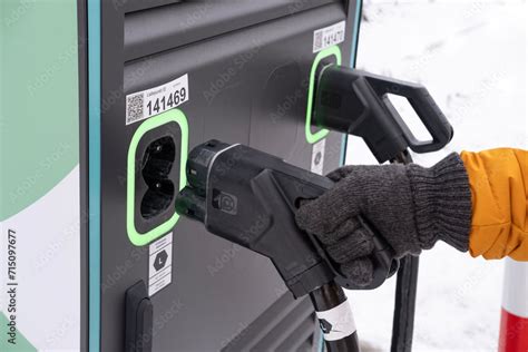 Man Holding DC Charging Connector In Hand Electric Vehicle Combined Charging System CCS Quick