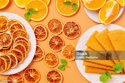 오렌지 파스티유와 과일 칩 프릴 얇게 썬 말린 과일을 공예 종이 상자에 섞고 과일 파스티유 마시멜로를 흰색 접시에 섞습니다 채식주의 라이프 스타일 파스티유 핸드메이드 감자