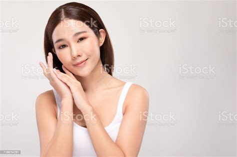 깨끗하고 신선한 피부행복과 쾌활한 긍정적 인 감정 회색 배경 아름다움과 화장품 개념에 고립 된 손을 들고 아름다운 아시아 젊은