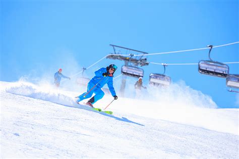 활동적인 라이프 스타일 중요한 노인 남성 스노우 스키 스키어 햇볕이 잘 드는 스키 리조트에서 즐기기 푸른 하늘을 배경으로 고속으로 스키를 타고 조각합니다 스키타기에 대한