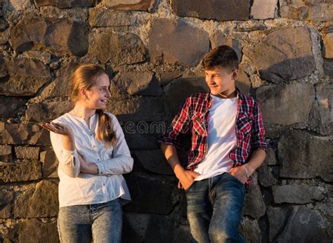 Ragazzo Felice E Ragazza Sorridenti Che Posano Vicino Alla Parete Di