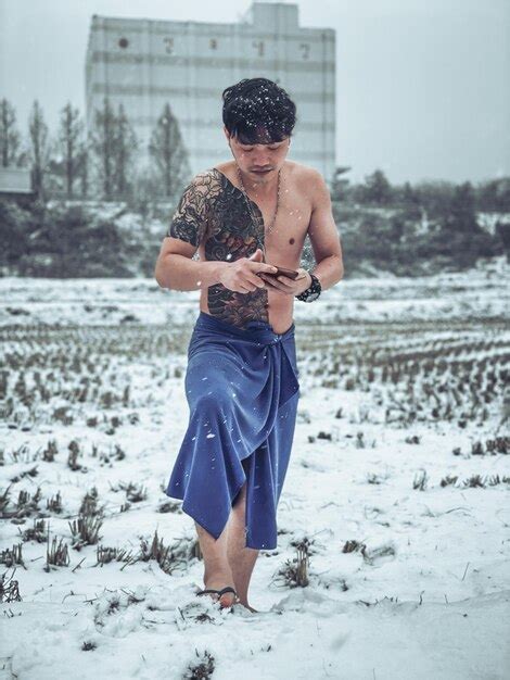 Premium Photo Full Length Of Shirtless Man Standing On Snow Covered Land