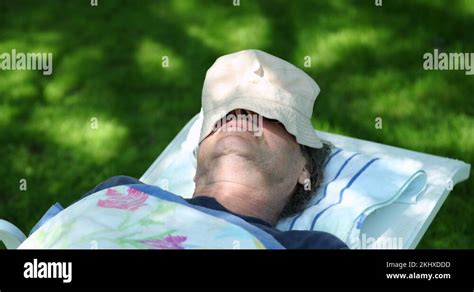 Older Man Napping Outside Covered By Hat Retired Senior Person
