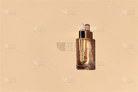 玻璃瓶化妆品血清米色背景。