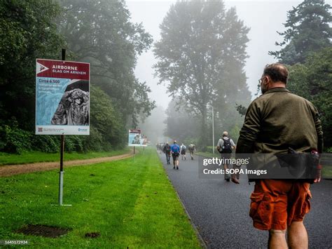 Participants Are Seen Walking Next To Placards That Explain The News