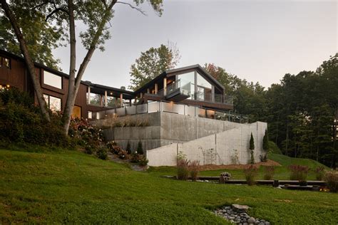 Une maison en surplomb d un lac dont les pièces se prolongent à l