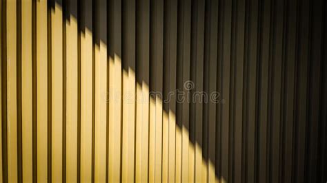 Light And Shadow Create Geometric Shapes And Divide The Wall Into Two