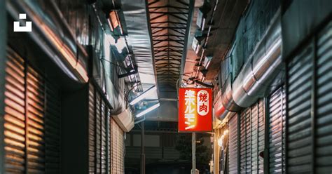 셔터가 달린 문과 천장에 매달린 빨간 간판이 있는 길고 좁은 복도 사진 Unsplash의 무료 구로사키 이미지