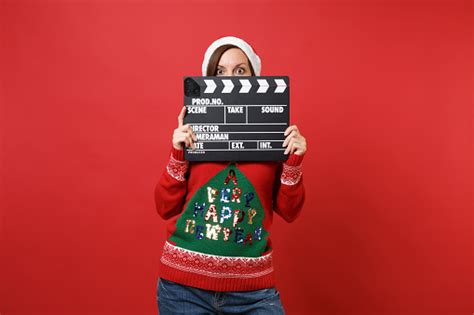 산타 소녀 숨기기 Clapperboard 밝은 빨간색 배경에 절연을 만드는 고전적인 흑인 영화로 얼굴을 덮고 충격 행복 한 새