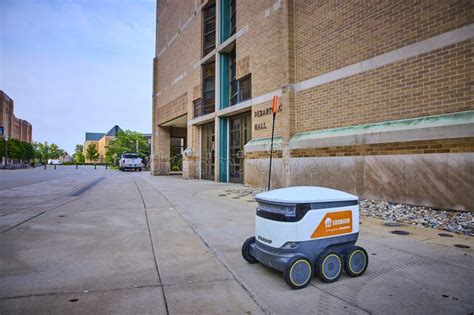 Autonomous Delivery Robot On University Campus Walkway Low Angle View