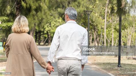 남자와 여자의 뒤 손을 잡고 공원에서 산책 사랑 결혼 라이프 스타일 목표 행복 한 은퇴 노인 부부는 시간을 보내고 이야기 공유 하 고 함께 휴식 생명 보험 개념 2명에 대한