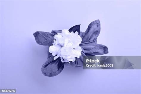 회색 직물로 감싸인 봄 의 환경 친화적 인 선물은 파란색에 흰색 모란 꽃 장식 장식 지속 가능한 선물 전통 일본 후로시키 스타일