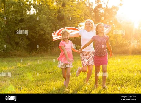 Glückliche Familie in ihrem Hinterhof zusammen sitzt und amerikanische Flagge hinter