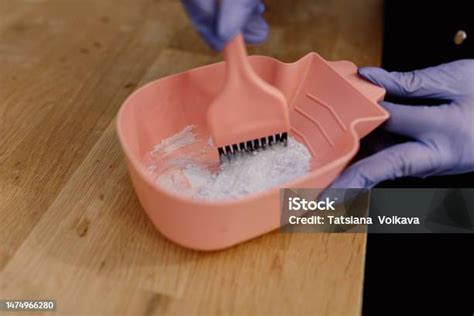 파란색 고무 장갑을 끼고 그릇에 염색약 색을 혼합하고 미용실에서 브러시를 섞은 여성 컬러리스트의 자른 사진 표백제에 대한 스톡