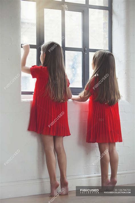 Девушки смотрят в окно — Два человека, Красный - Stock Photo | #126796720