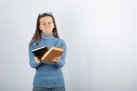 Free Photo Portrait Of A Woman In Eyeglasses Holding Two Books On