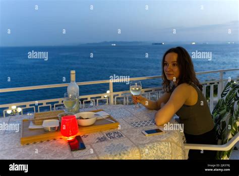 Young Girl On The Balcony With A Romantic Table By Candlelight And A