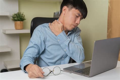 Stressed Young Asian Businessman Massaging Stiff Shoulder Neck When