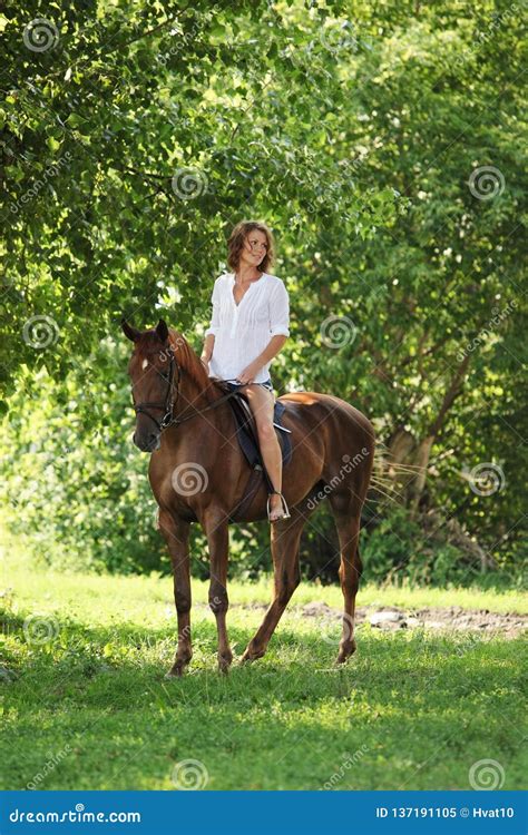 Beautiful Model Girl Rides With Horse In Woods Glade At Sunset Stock