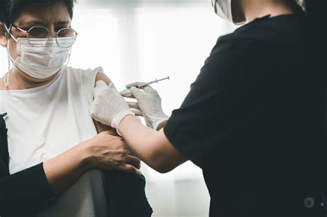 노인 아시아 여자 예방 접종 의사와 함께 고위 환자에 게 총을 주는 Covid19 백신 주입 개념 20 24세에 대한 스톡 사진