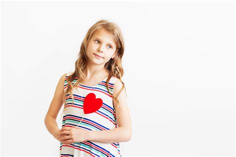 흰색 배경에 대해 사랑 스러운 어린 소녀의 근접 촬영 초상화 빨간 종이 마음에 들고 아름 다운 십 대 소녀입니다 발렌타인의 하루입니다 첫 사랑 개념 심장에 대한 스톡 사진