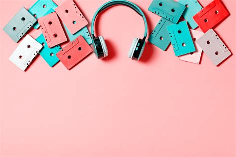 파스텔 배경 복사 공간 상단보기에 밝은 색상의 오디오 카세트와 파란색 이어폰을 그린 복고풍 음악 배경입니다 복고풍 오디오 테이프