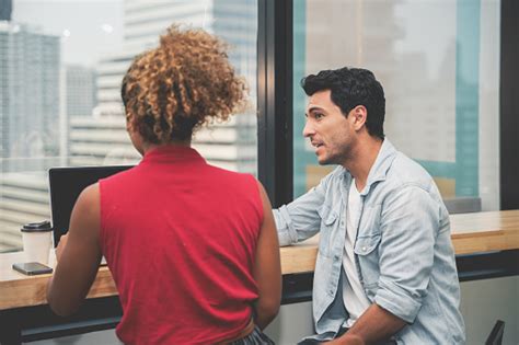 현대 사무실에서 일 하는 젊은 디자이너의 부부 두 동료는 노트북을 통해 재미 있는 프로젝트를 논의 사업가의 작은 팀 웃 고 컴퓨터에서 함께 보고 도서관에서 학생 가리키기에