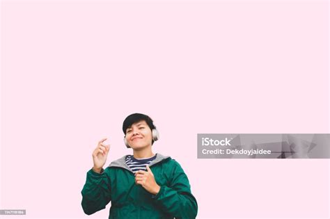 아시아 잘생긴 젊은 여자 그린 자 켓 착용 헤드셋 듣기 팝 음악과 춤 핑크 파스텔 배경에 헤드폰에서 행복 재미 Mp3 플레이어에 대한 스톡 사진 및 기타 이미지 Istock