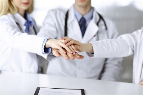 Grupo de médicos que se unen en círculo y están listos para ayudar a