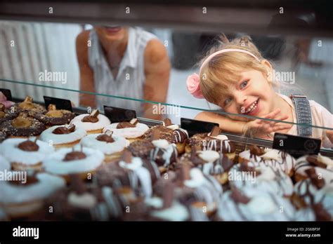 Mother And Daughter Buying Mouth Watering Donuts Together At Store