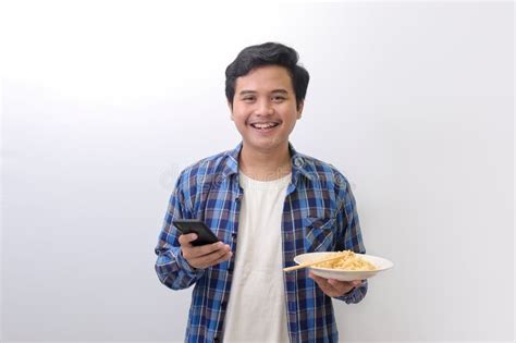 Portrait Of Happy Asian Man In Blue Plaid Shirt Eating Delicious