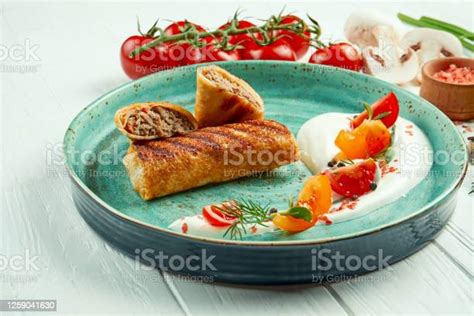 흰색 나무 배경에 사워 크림과 파란색 접시에 고기로 채워진 고전적인 우크라이나어 팬케이크 0명에 대한 스톡 사진 및 기타 이미지 Istock