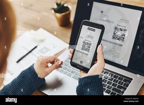 Woman Scanning QR Code From Invoice To Make Payment Using Fast Secure Payment System And