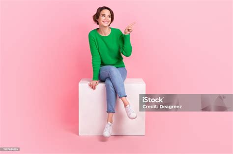 매력적인 광고 마케터가 분홍색 배경에 격리된 흰색 연단 직접 손가락 모형 참신함에 앉아 있는 전체 길이 크기 사진 앉음에 대한