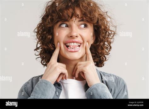 Ginger Joyful Woman Showing Her Tongue And Pointing Fingers At Her