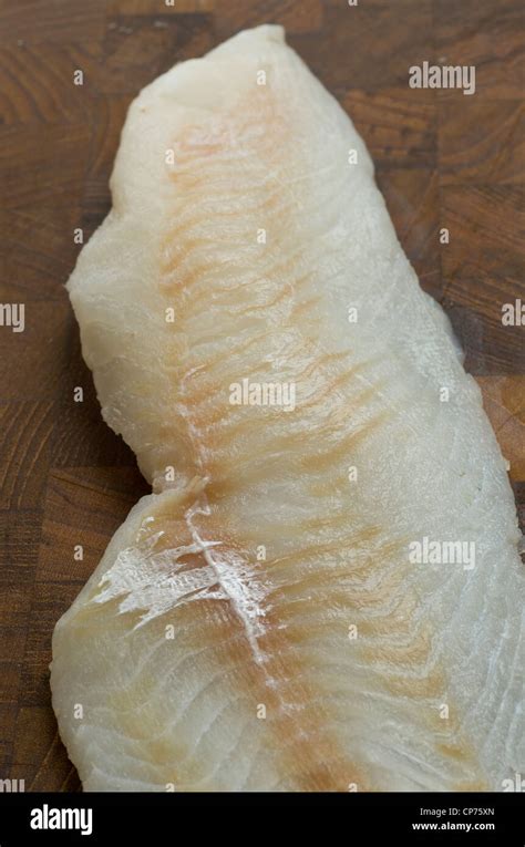 Close Up Of Fresh Raw Cod Fillet On A Wood Cutting Board Stock Photo Alamy