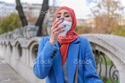 독감에 대한 무슬림 여성이 도시 거리에서 걷고 종이 조직에서 재채기를 하고 있습니다 30 34세에 대한 스톡 사진 및 기타