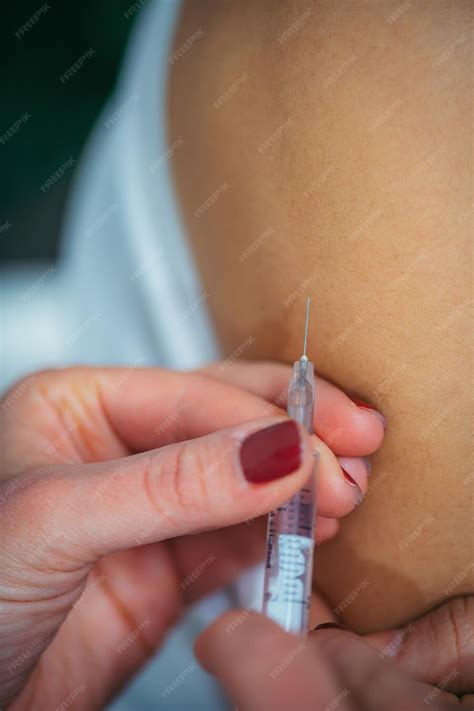 Premium Photo Female Doctor Injecting Syringe On Woman Shoulder In