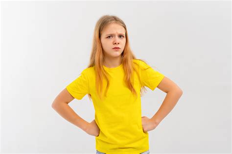 불쾌한 소녀가 엉덩이에 손을 잡고 화를 내며 카메라를 바라 보는 초상화는 누군가의 의견과 일치하지 않습니다 스튜디오 촬영 흰색
