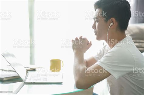 아시아 의 젊은 학생 남자 기업가 집에서 온라인으로 학습 컴퓨터와 함께 작동 이어폰을 착용 E러닝 웨비나 미팅 유능한 전염병의 사회적 거리 18 19세에 대한 스톡 사진 및