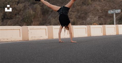 검은 탱크 탑과 검은 반바지를 입은 여자가 낮에 회색 아스팔트 도로에서 점프 사진 Unsplash의 무료 여자 이미지