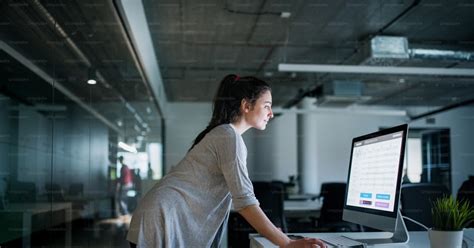 사무실의 책상에 서서 컴퓨터를 들고 일하는 젊은 사업가의 측면 모습 사진 Unsplash의 슬로바키아 이미지