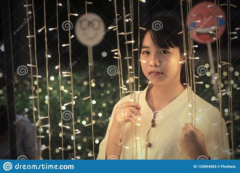 Una Ragazza Asiatica Sveglia Che Esamina Principale Illuminazione