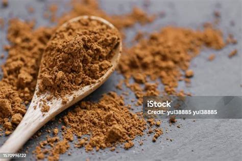 구아라나 천연 생체 자극제 검은 배경에 컵에 있는 나무 숟가락에 있는 과라나 가루 천연 강장제 대체 의학 및 동종 요법 보충제와 비타민 스포츠 영양 0명에 대한 스톡 사진