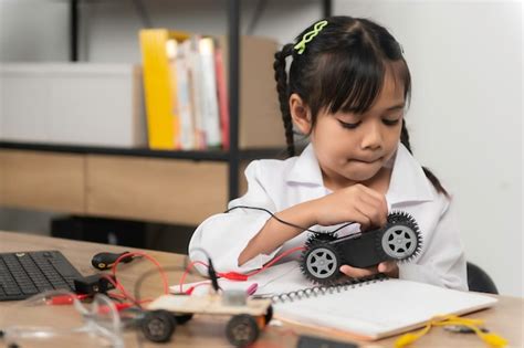 Premium Photo Asian Littlle Girl Constructing And Coding Robot At