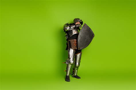 갑옷을 입고 방패를 들고 역사적인 판타지를 구현하는 생생한 녹색 배경을 배경으로 자신 있게 서 있는 중세 기사 20 24세에 대한 스톡 사진 및 기타 이미지 Istock