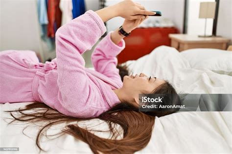침실에서 침대에 누워 스마트폰을 사용하는 어린 중국 소녀 누워있기에 대한 스톡 사진 및 기타 이미지 누워있기 메시지
