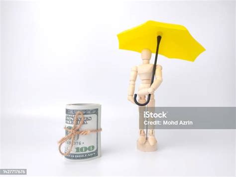흰색 배경에 노란색 우산과 지폐를 들고 있는 나무 마네킹 비즈니스 개념 0명에 대한 스톡 사진 및 기타 이미지 0명 개념
